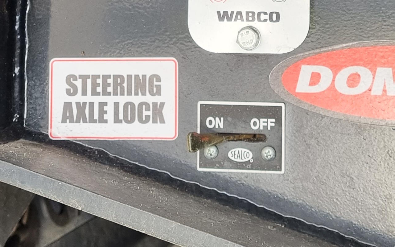 What are rear-steer axles and why are they used?